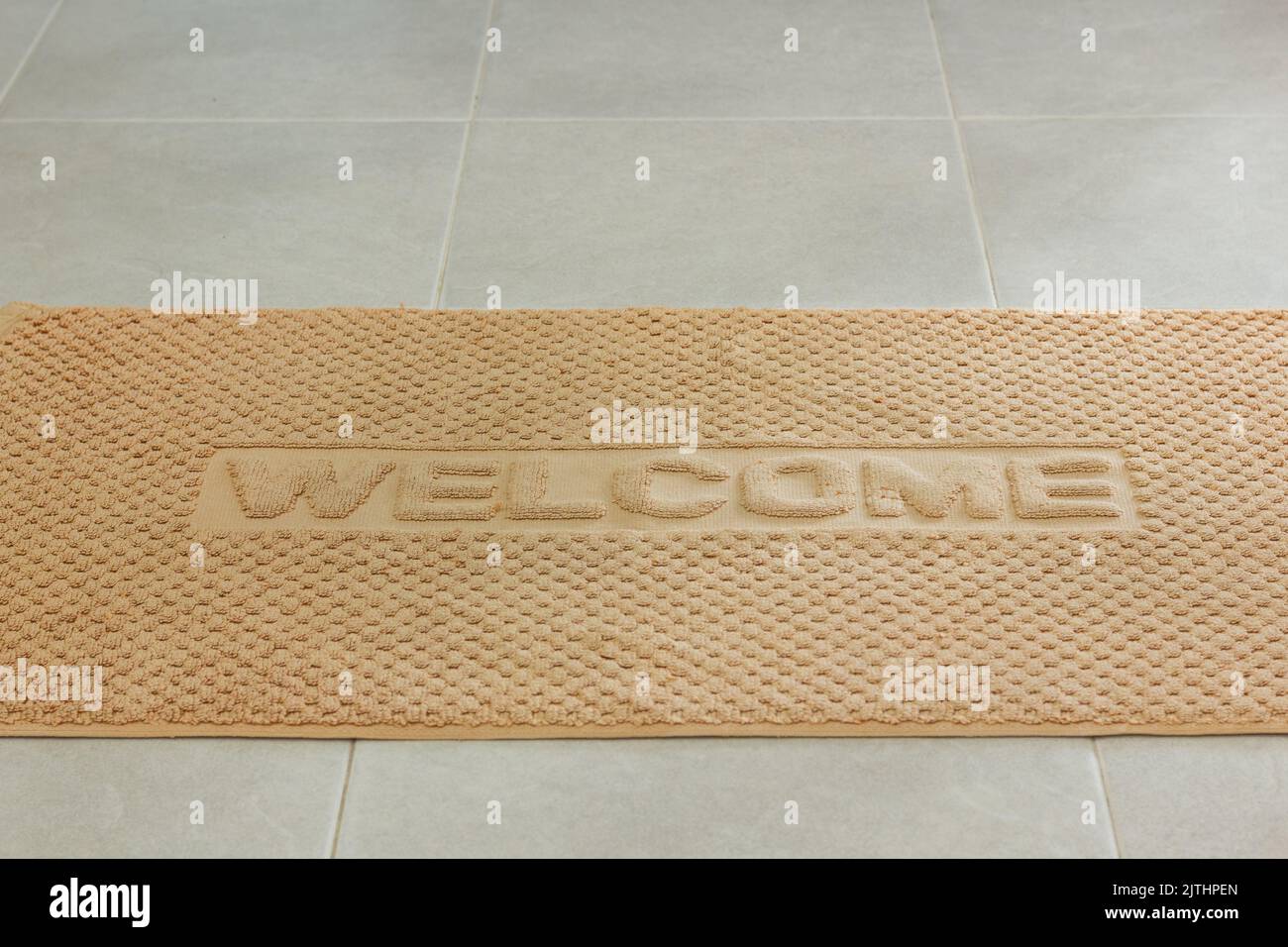Bath towel with welcome sign on the bathroom floor. Hotel accommodation ...