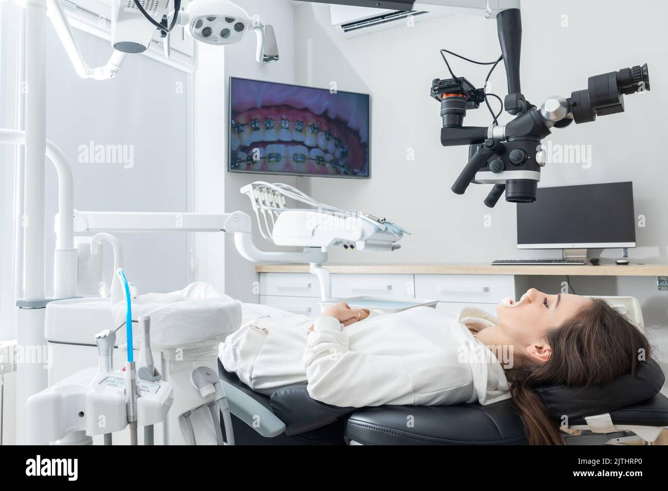 Using dental microscope treating patient teeth at dental clinic office ...