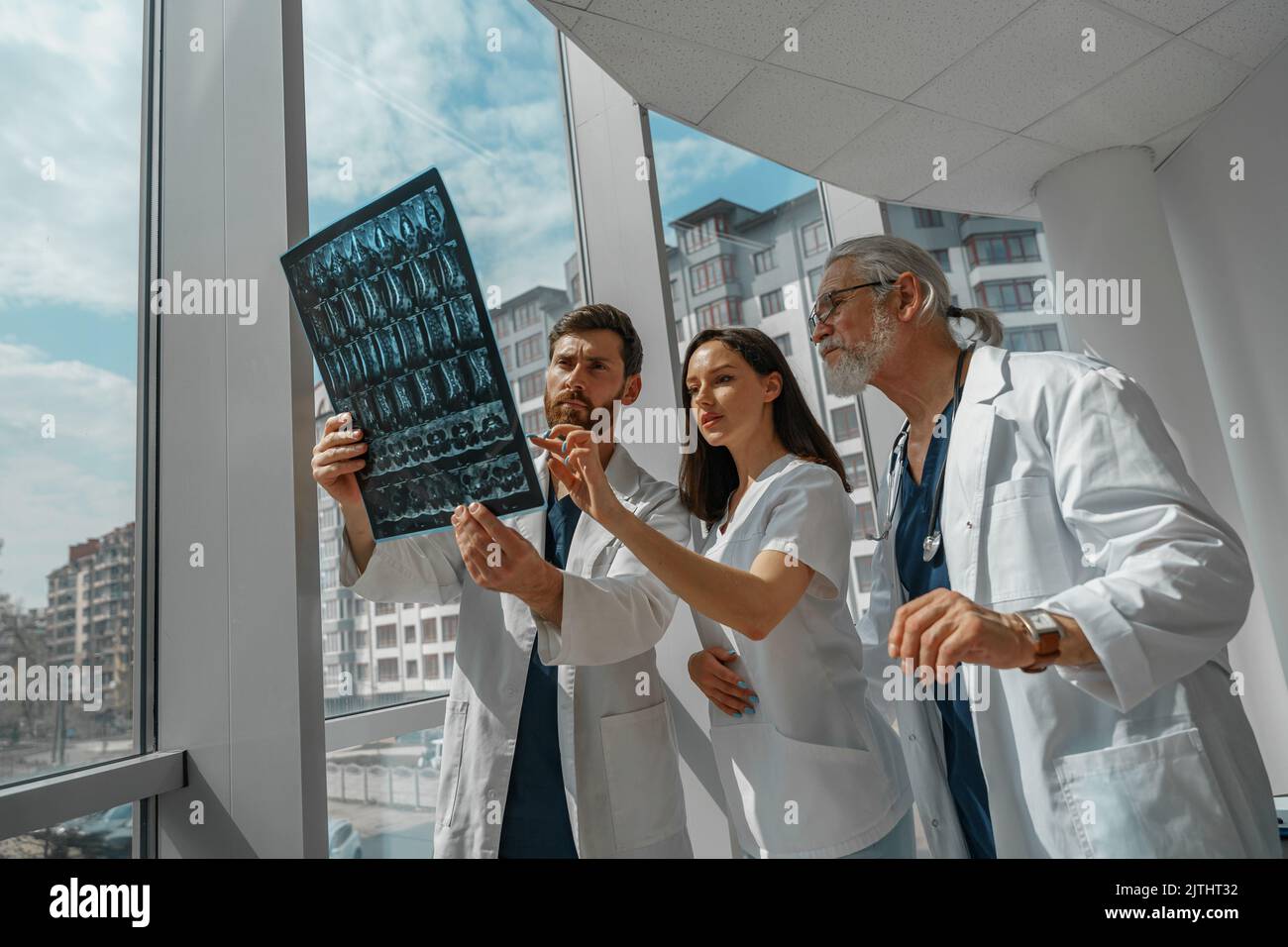 Doctor colleagues look and discuss X Ray or MRI scan of the patient ...