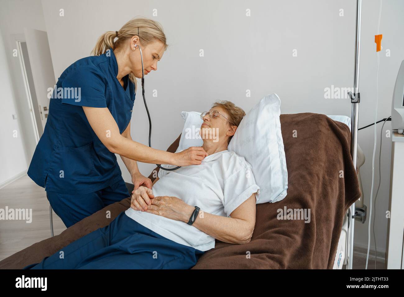Female doctor therapist listening to old woman's patient breathing ...
