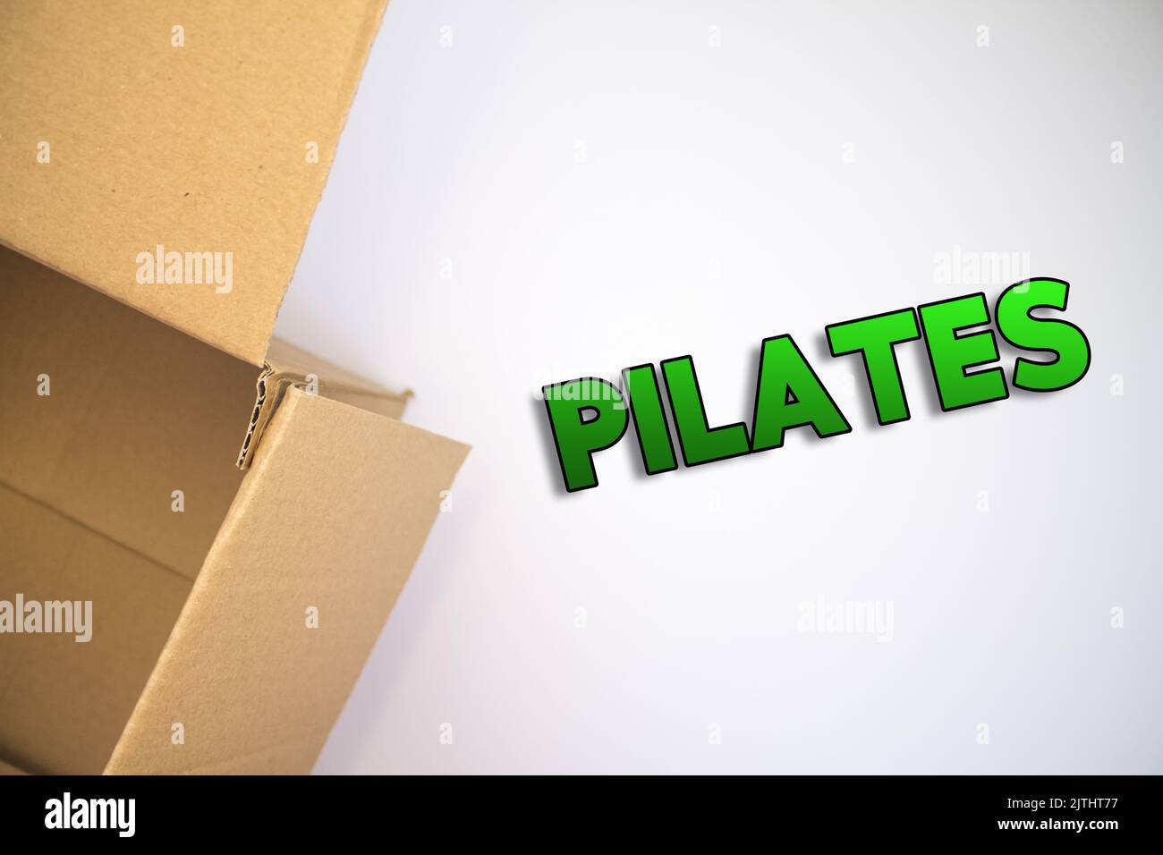 Pilates word with cardboard box. Brown folded cardbox Stock Photo - Alamy
