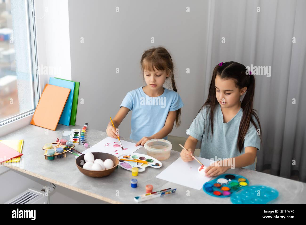 two little girls with brush painting on table, education, watercolor ...