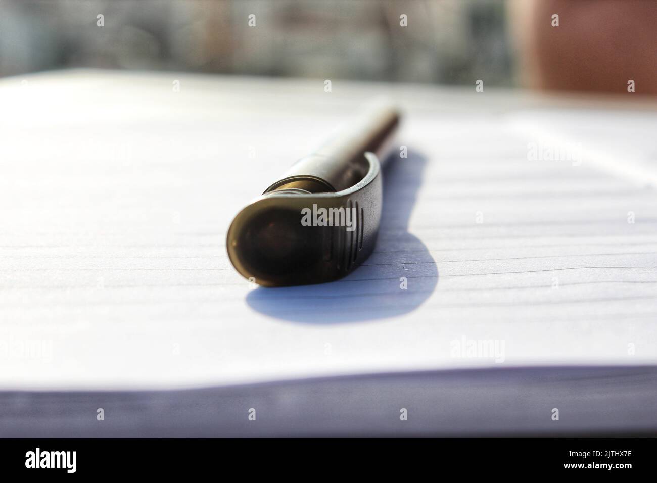 A black Ballpoint Pen lying on blank page Stock Photo - Alamy