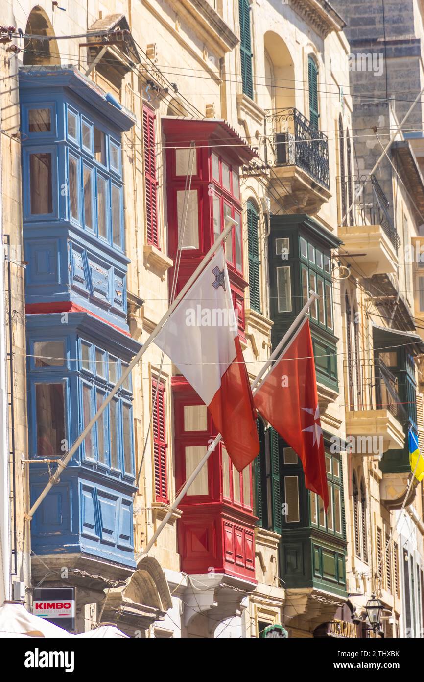 Malta flags waving from the colorful traditional maltese balconies in ...