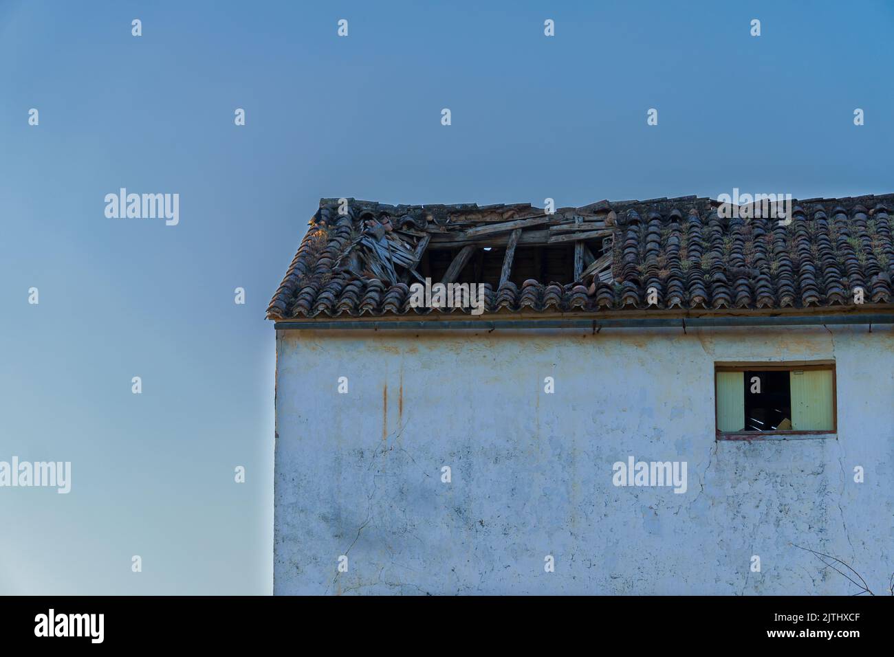 abandoned house with sunken roof and blue sky in the background Stock ...