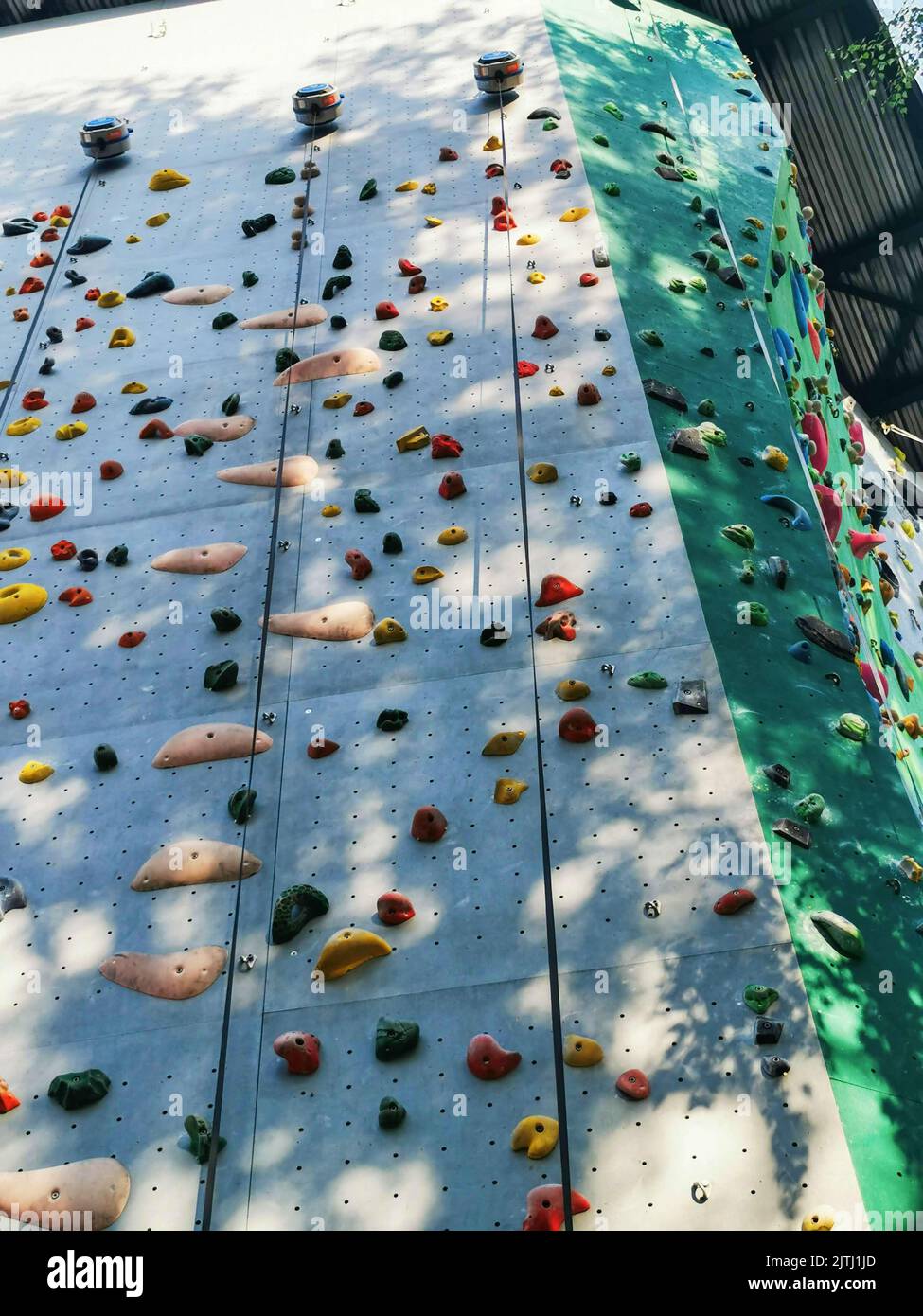 Artificial rock climbing bouldering wall showing various colored grips ...