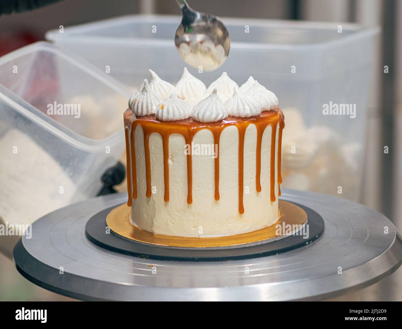 professional baker decorating a chocolate and cream cake with salty ...