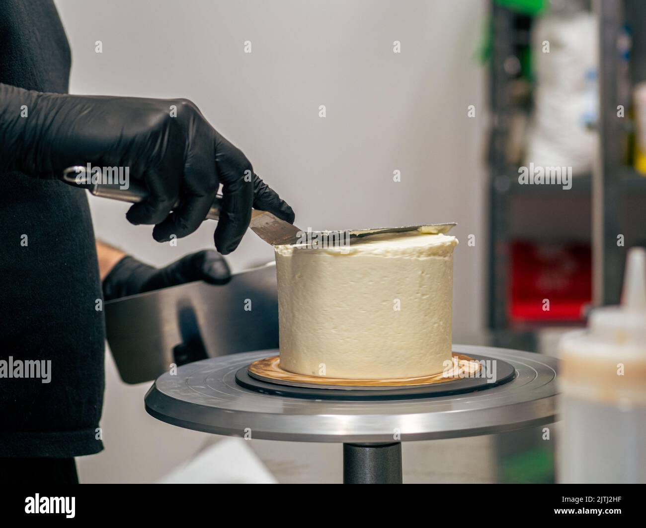 professional baker decorating a chocolate and cream cake with salty ...