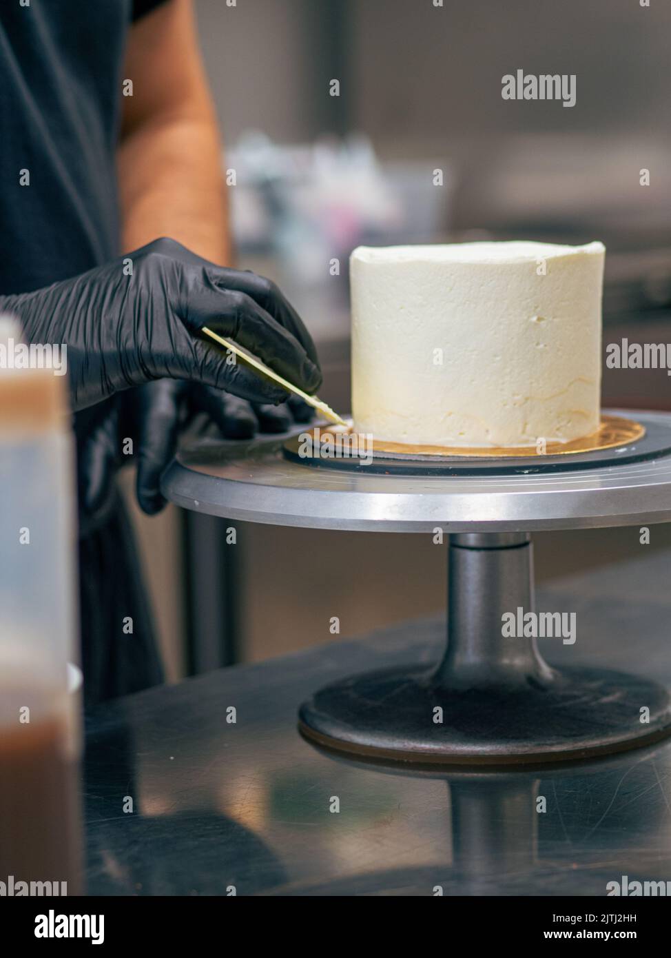 professional baker decorating a chocolate and cream cake with salty ...
