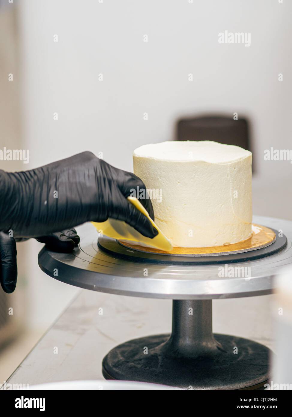 professional baker decorating a chocolate and cream cake with salty ...
