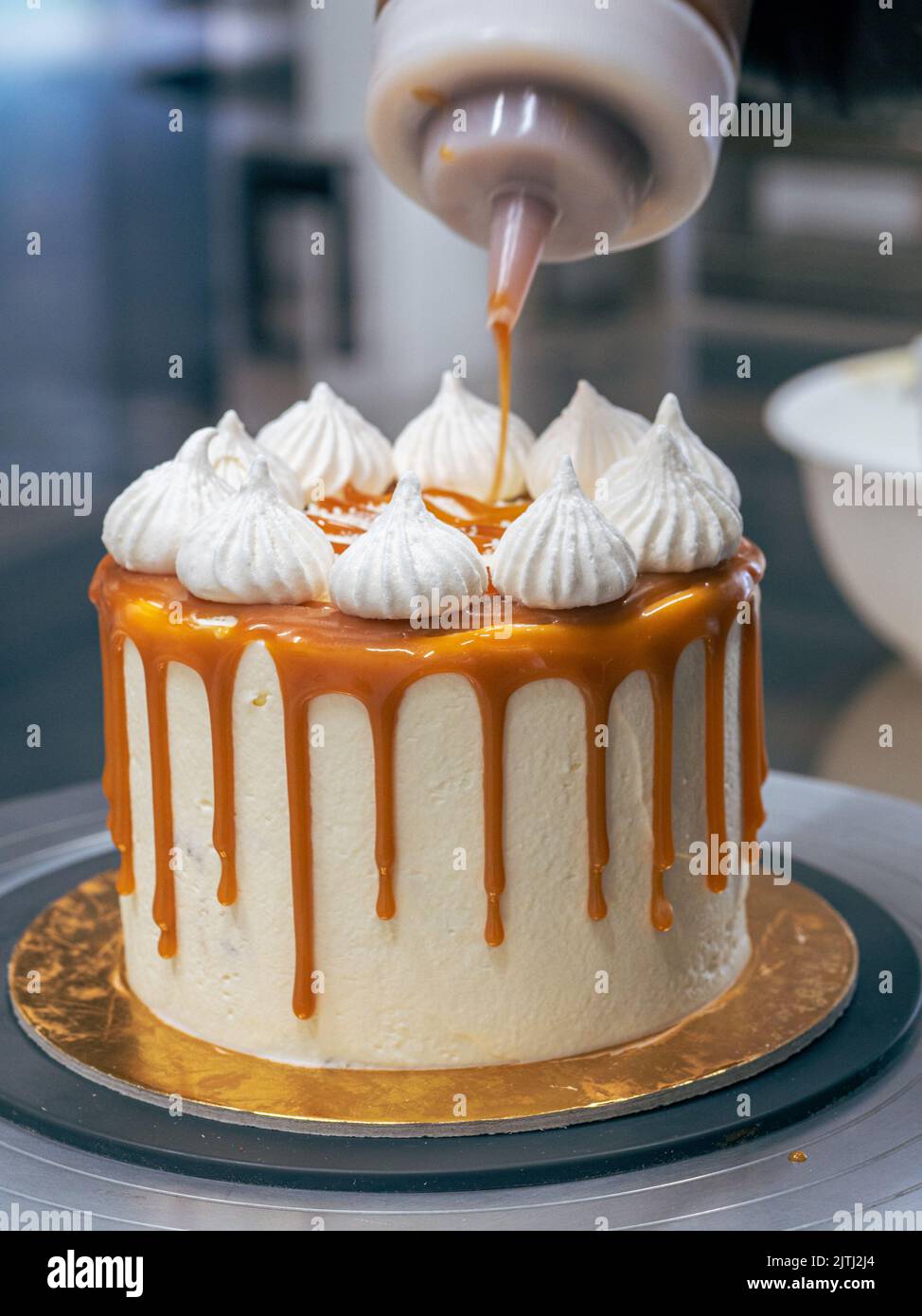 professional baker decorating a chocolate and cream cake with salty ...