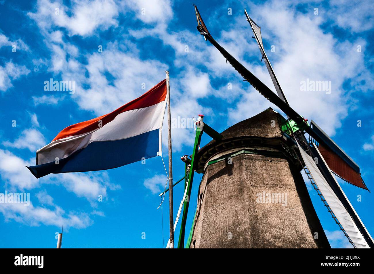 Traditional windmill with a Dutch flag at De Zaanse Schans Stock Photo ...