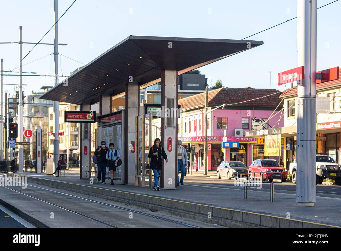 People waiting on the platform at the Kensington tram stop on Sydney ...