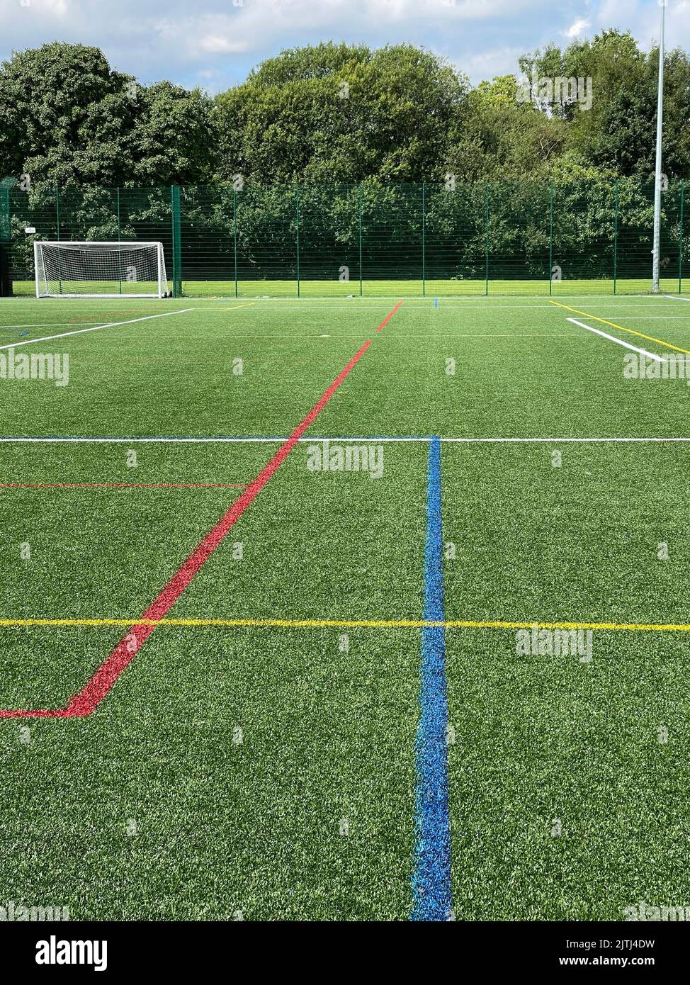 An artificial football field with colorful lines and nets, vertical ...
