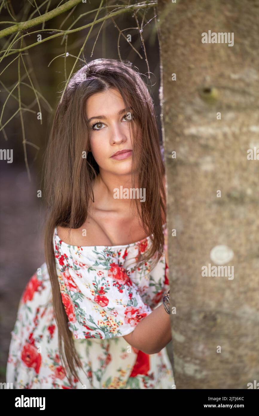 The vertical portrait of an attractive Caucasian girl sneaking from ...