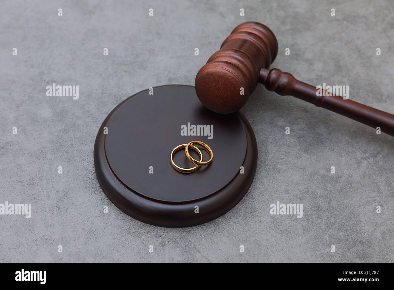 Law theme. Judge gavel wedding rings on concrete stone grey background ...