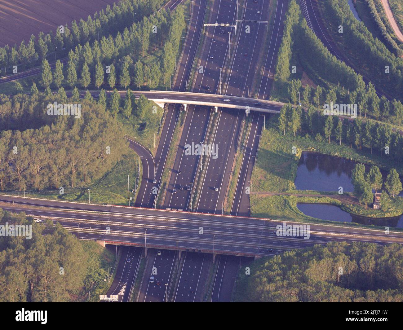 A bird's eye view of highways and bridge roads surrounded by trees ...