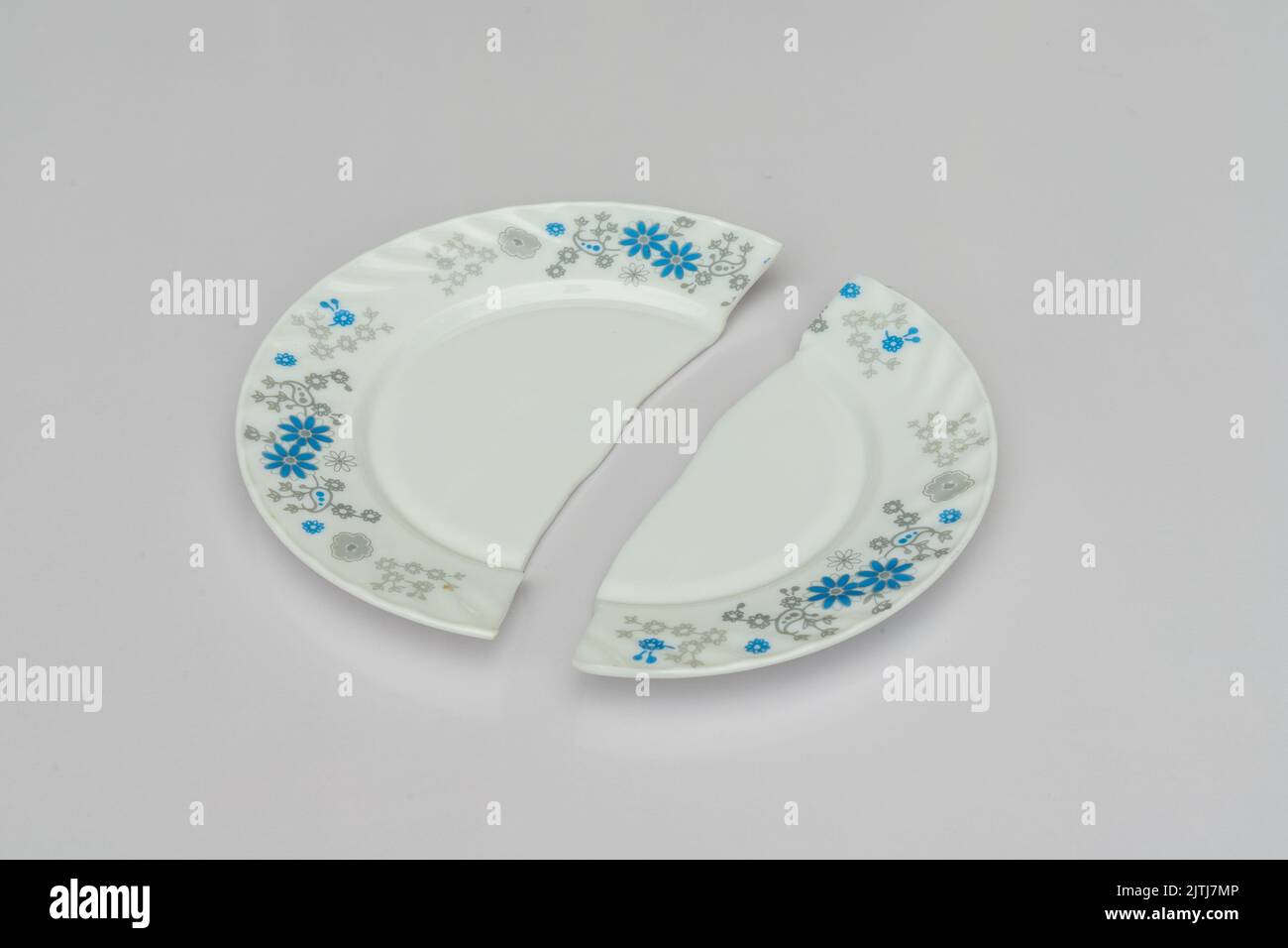 Broken white plate in half on isolated white background or concept of ...