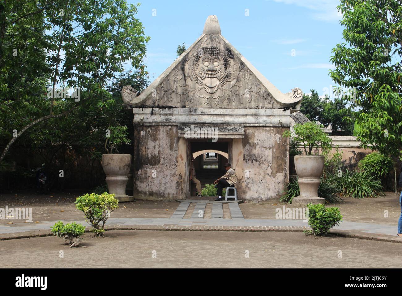 An old gate with carved heads of wayang figures in the Taman Sari ...