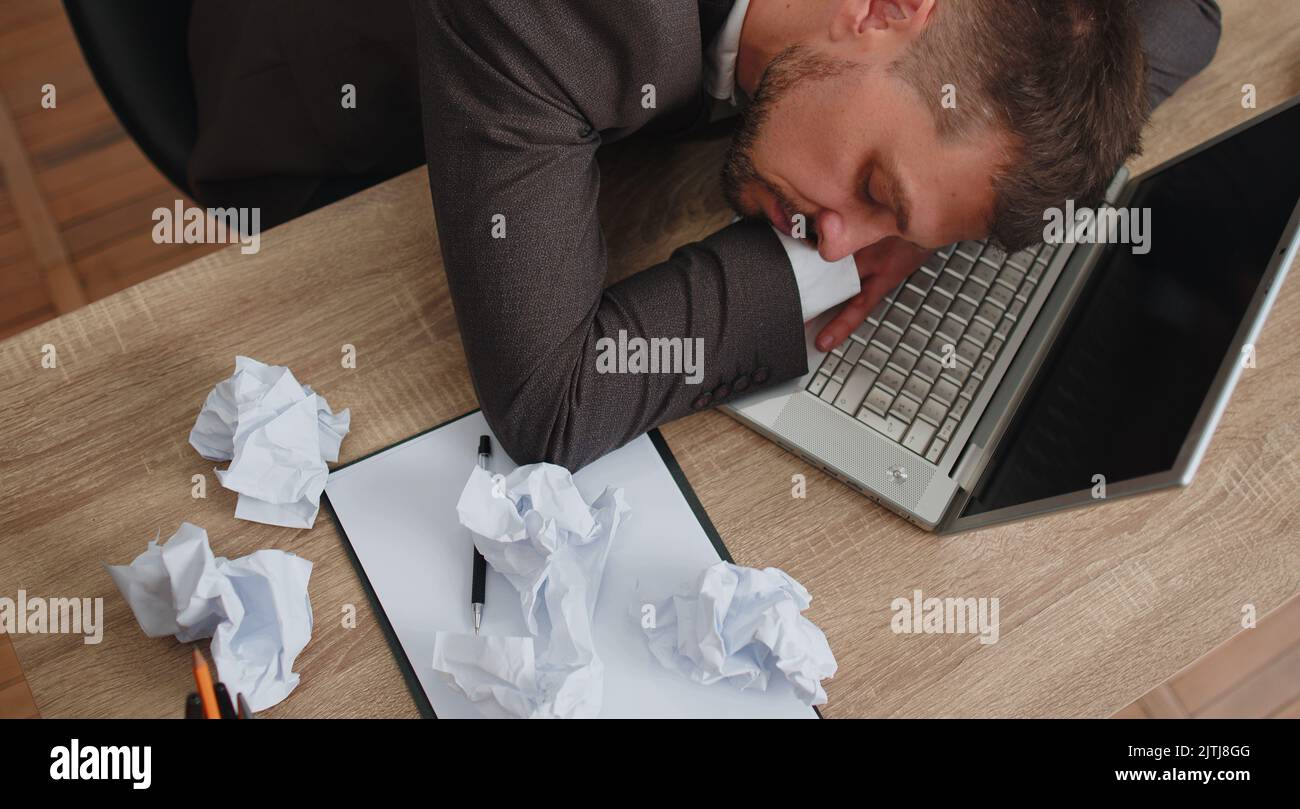 Bored sleepy businessman programmer software developer in formal wear suit falling asleep after ...