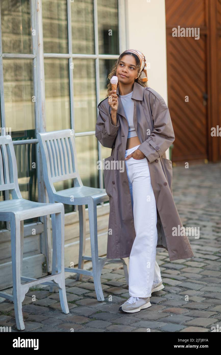 full length of african american woman in headscarf and trench coat ...