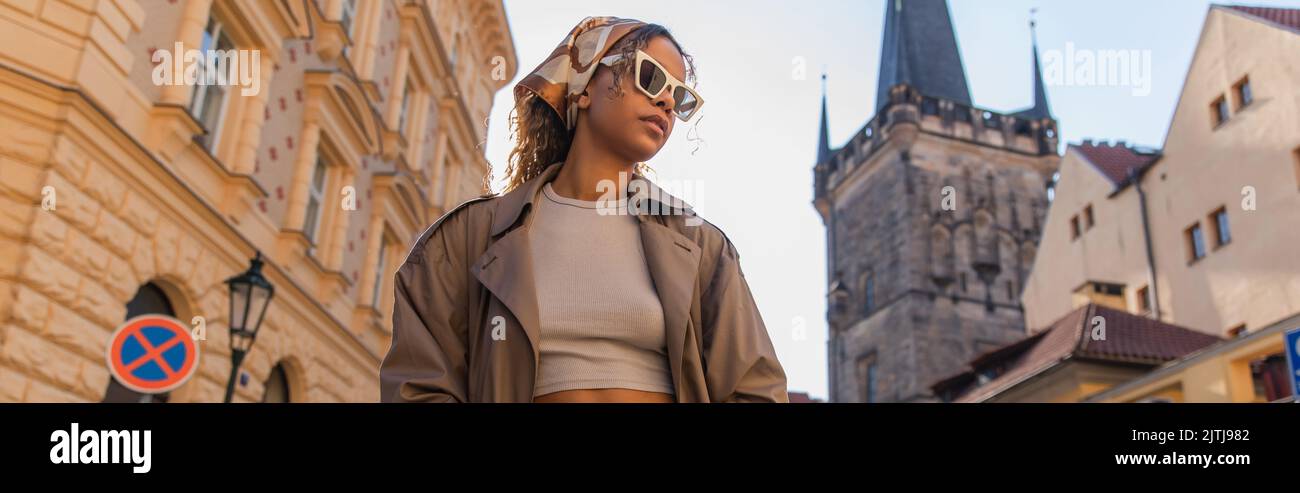 stylish african american woman posing near old town hall tower in ...