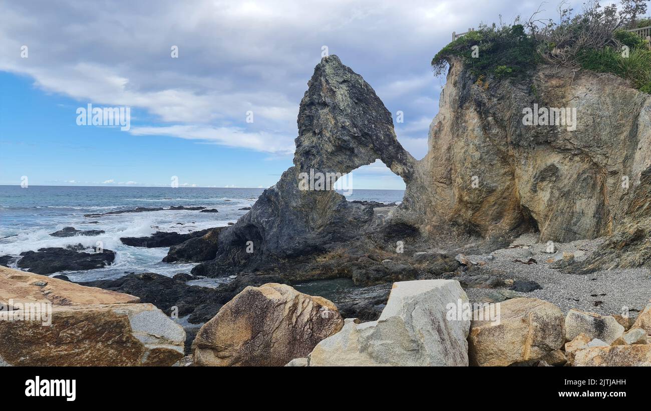 A huge rock with a hole on a beach in Australia Stock Photo - Alamy