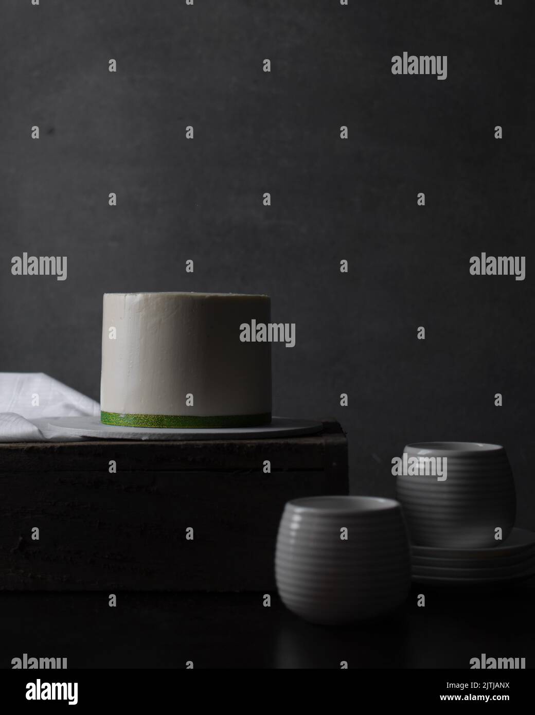 White buttercream cake with a green ribbon on a wood crate Stock Photo ...