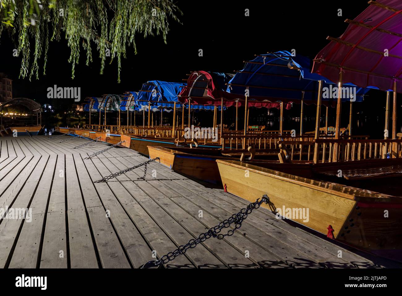 The historic pletna rowing boats of Bled docked on the quay at night ...