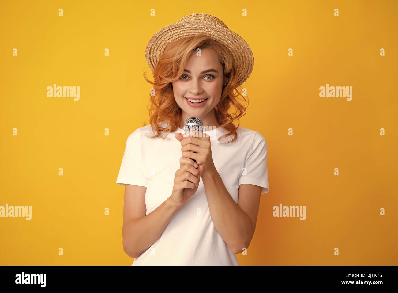 Young pretty woman singing a song with a microphone, presenting an ...