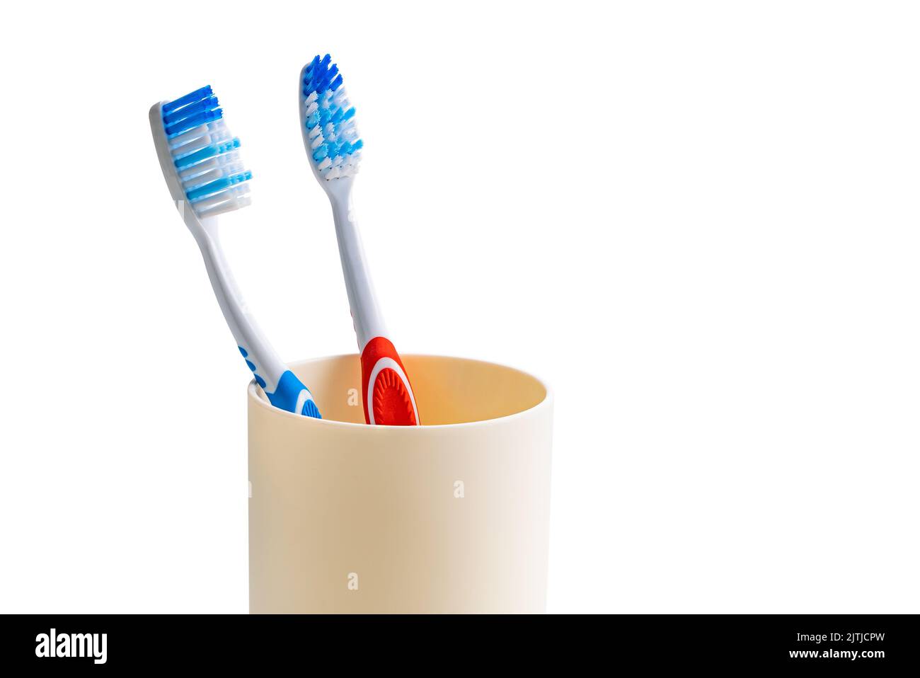 View of new toothbrushes red and blue handle in plastic cup isolated on ...