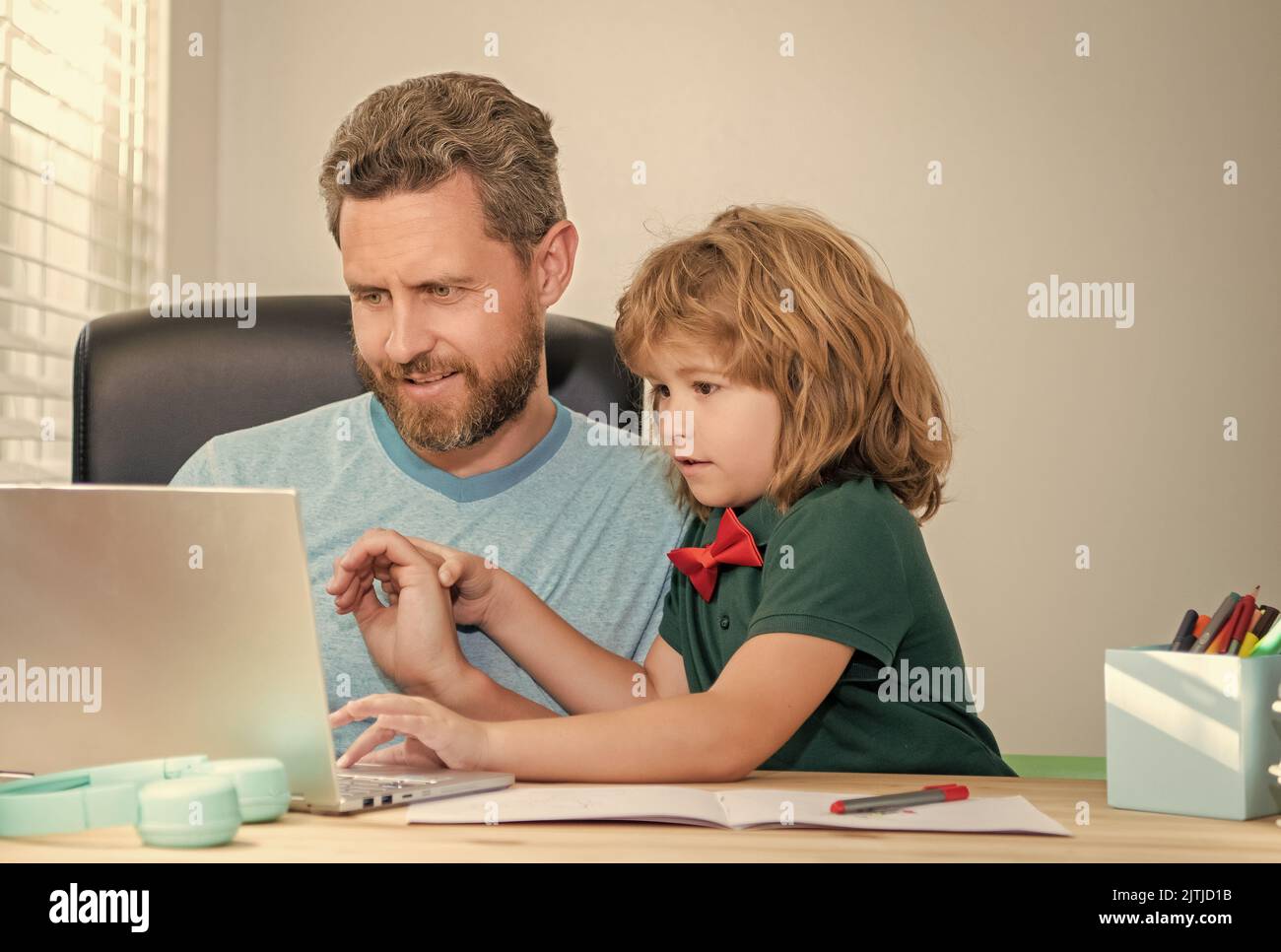 back to school. dad and son use computer at home. family and parenthood ...
