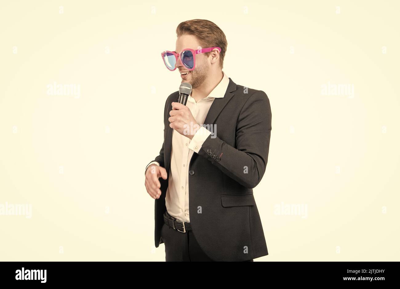 Professional man showman in funny glasses speak to microphone isolated ...