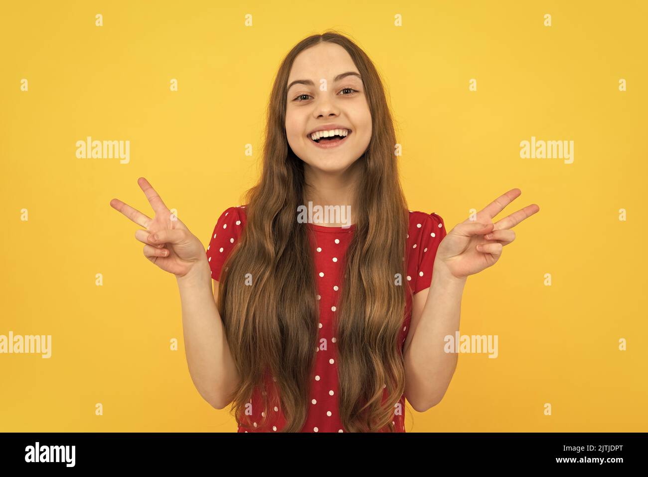 Teenager child girl standing over isolated yellow background showing ...