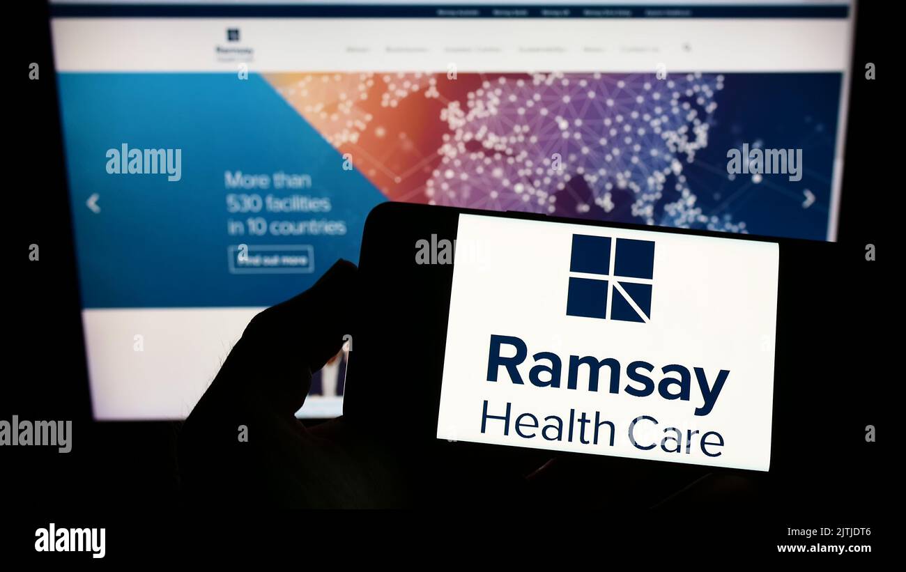 Person holding smartphone with logo of Australian company Ramsay Health ...