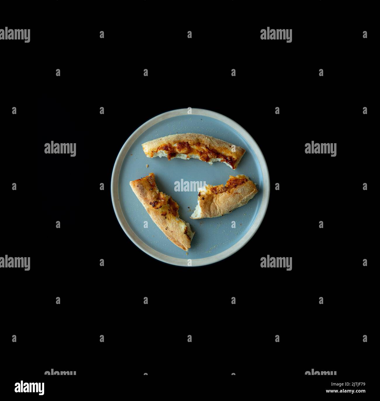 Pizza dough crusts left on a plate. Pizza has been eaten, but the crust ...