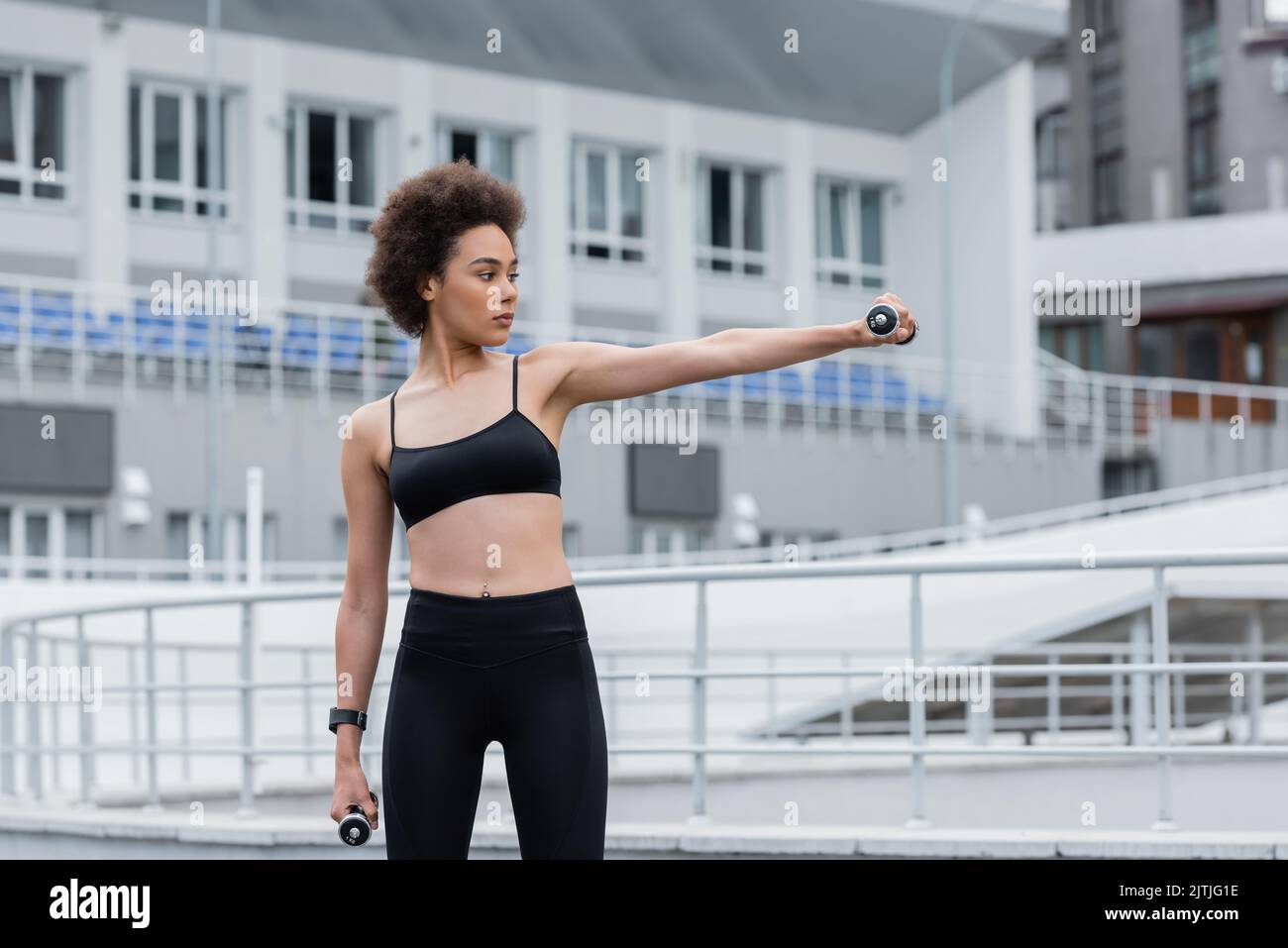 athletic african american woman with outstretched hand working out with ...
