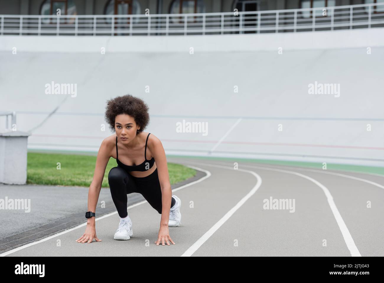 young african american jogger standing in low start pose on track Stock ...