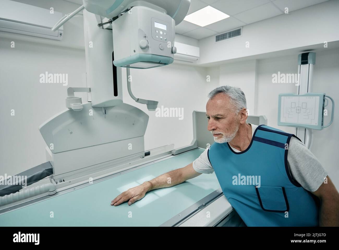 Male patient with wrist injury during x-ray procedure on modern X-ray ...