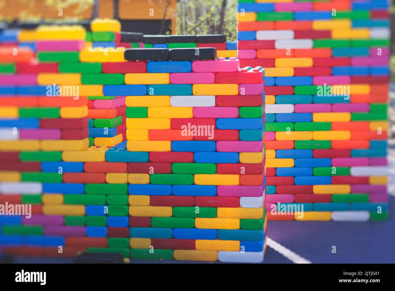 Children play colorful big toy blocks in kindergarten day care center playground, kids playing ...