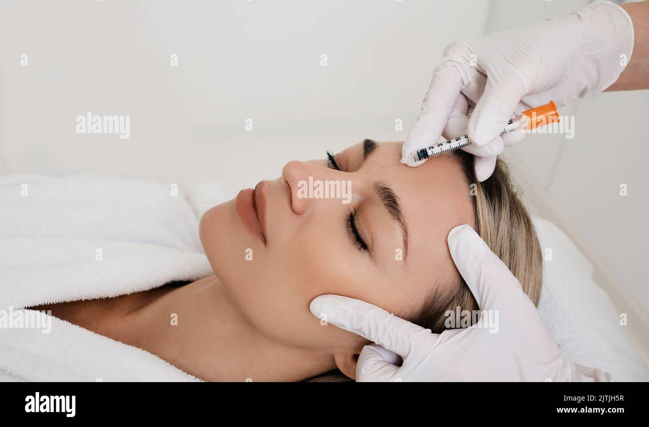 Beauty injections in woman's forehead for blocking mimic wrinkles ...