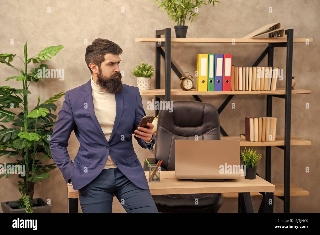Simple way to connect. Serious man using smartphone at work. Smartphone ...