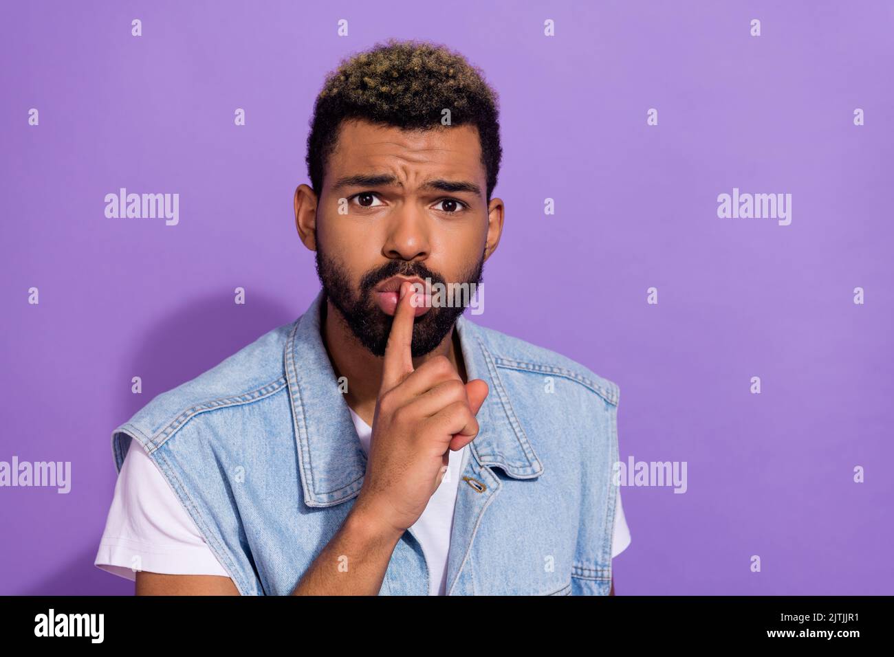Photo of cute serious guy dressed denim vest asking keep silence empty ...