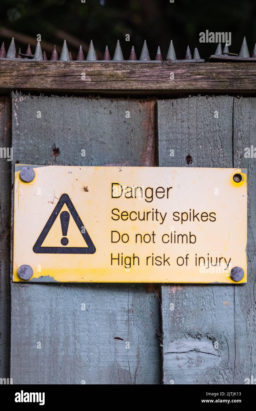 Security spikes and warning notice on a fence in Cardiff, Wales, UK ...