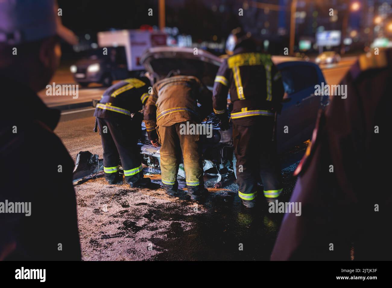 Group of fire men extinguishing and put out burning car crash after ...