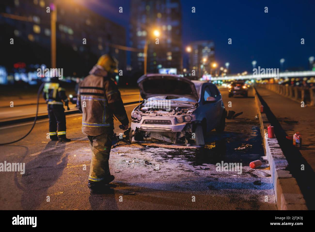 Group of fire men extinguishing and put out burning car crash after ...