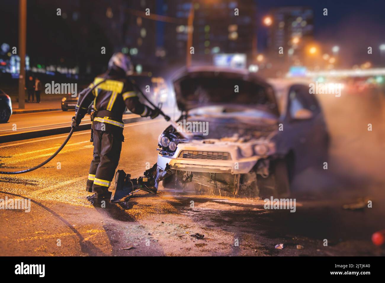 Group of fire men extinguishing and put out burning car crash after ...