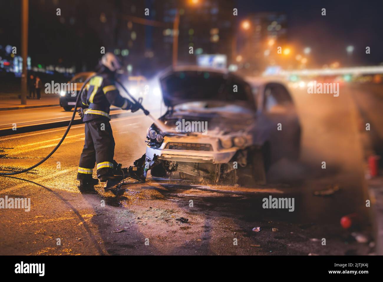 Group of fire men extinguishing and put out burning car crash after ...