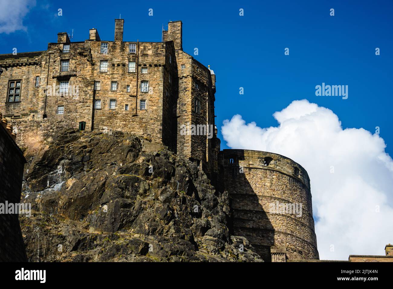A low angle shot of the Edinburgh Castle on a hill under a cloudy sky ...