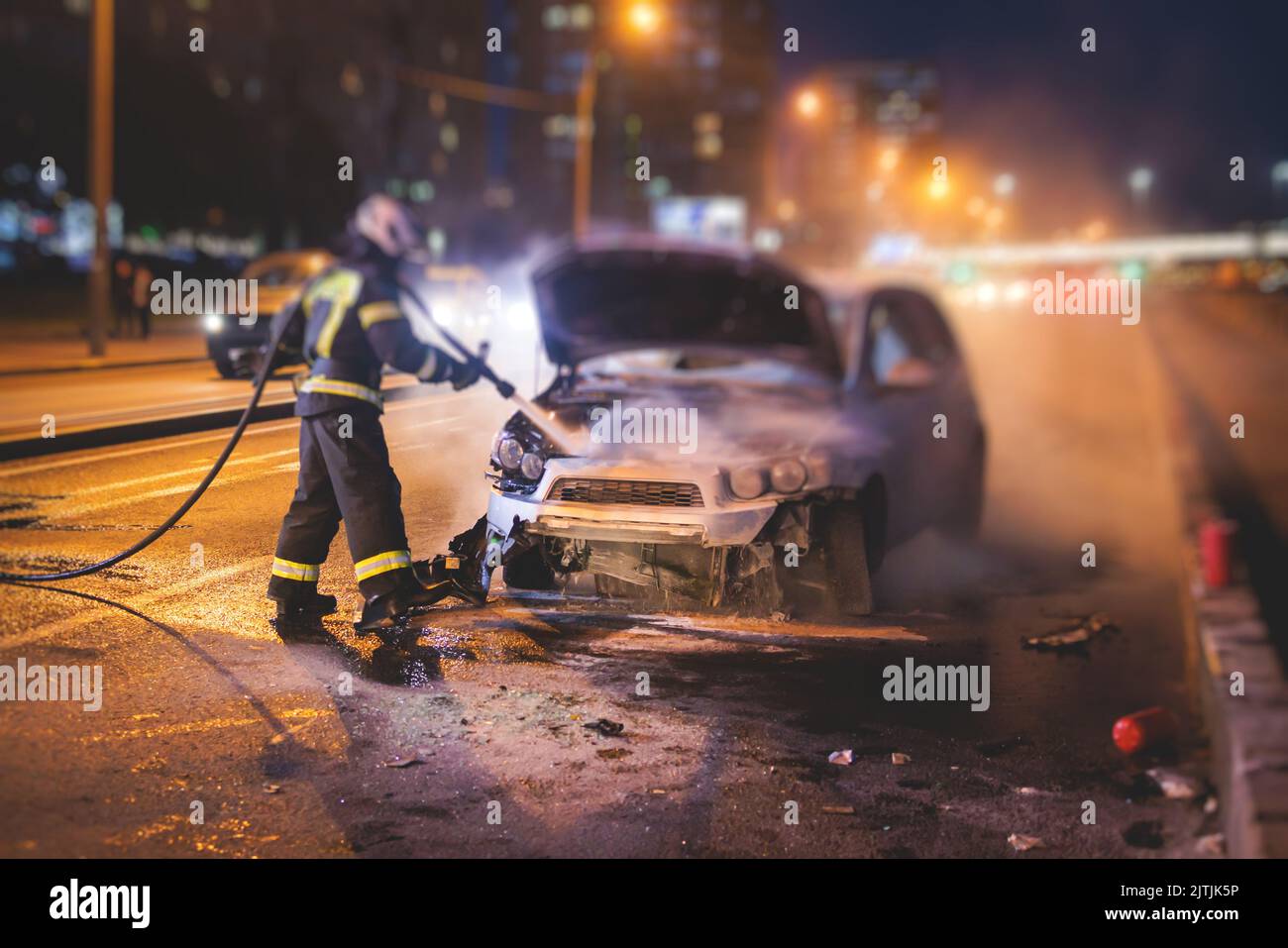 Group of fire men extinguishing and put out burning car crash after ...